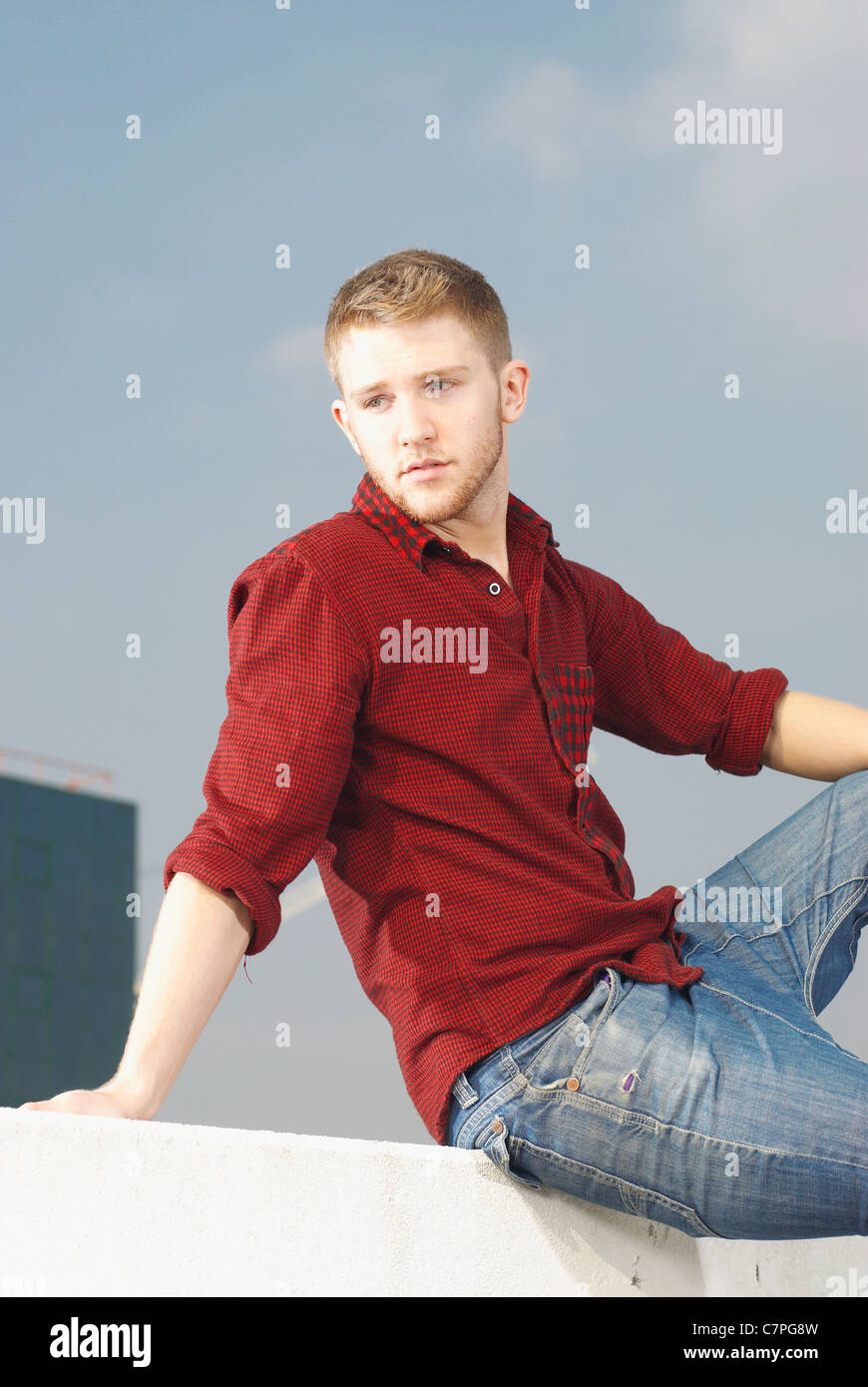 Man sitting on wall Stock Photo - Alamy