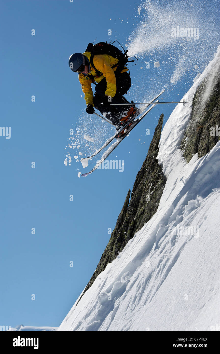 Skier jumping over steep mountain face Stock Photo - Alamy
