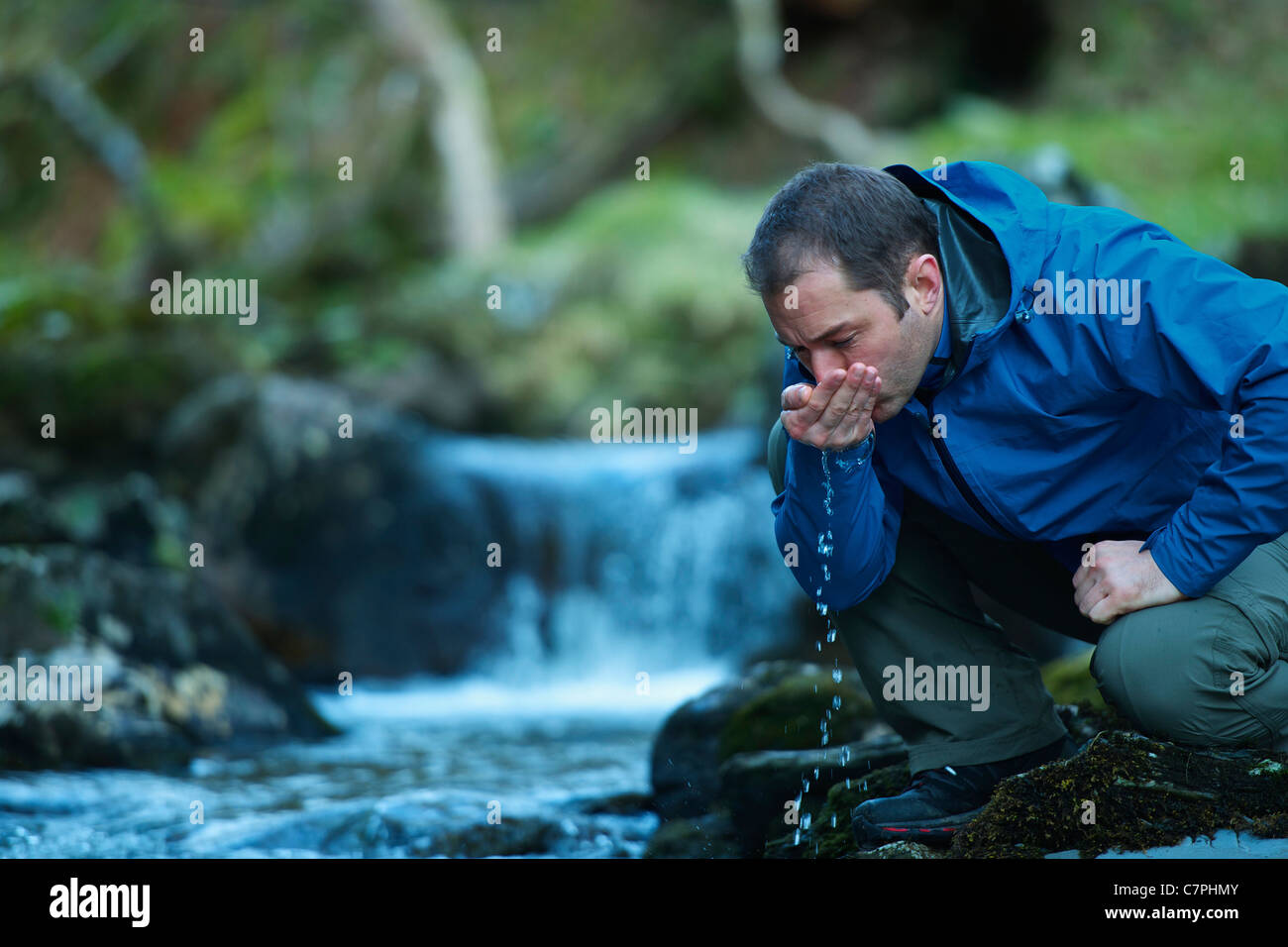 Man drinking water from stream Stock Photo - Alamy