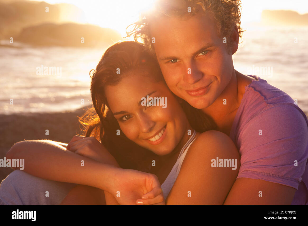 Couple hugging on beach at sunset Stock Photo - Alamy