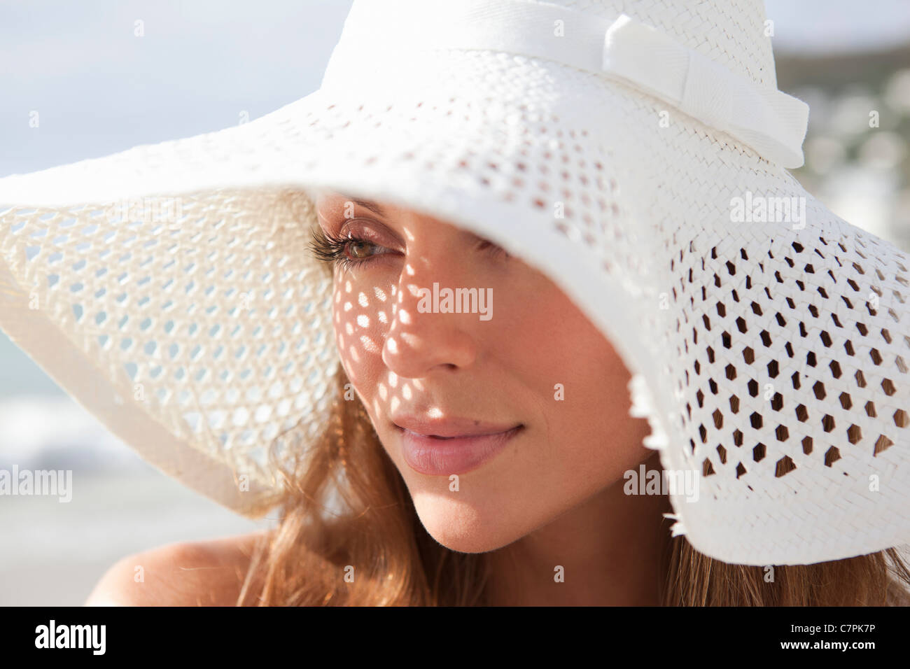 Woman wearing sunhat on beach Stock Photo - Alamy