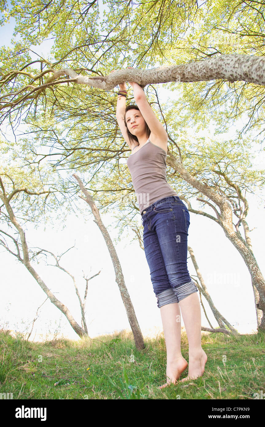 Girl climbing tree outdoors Stock Photo - Alamy