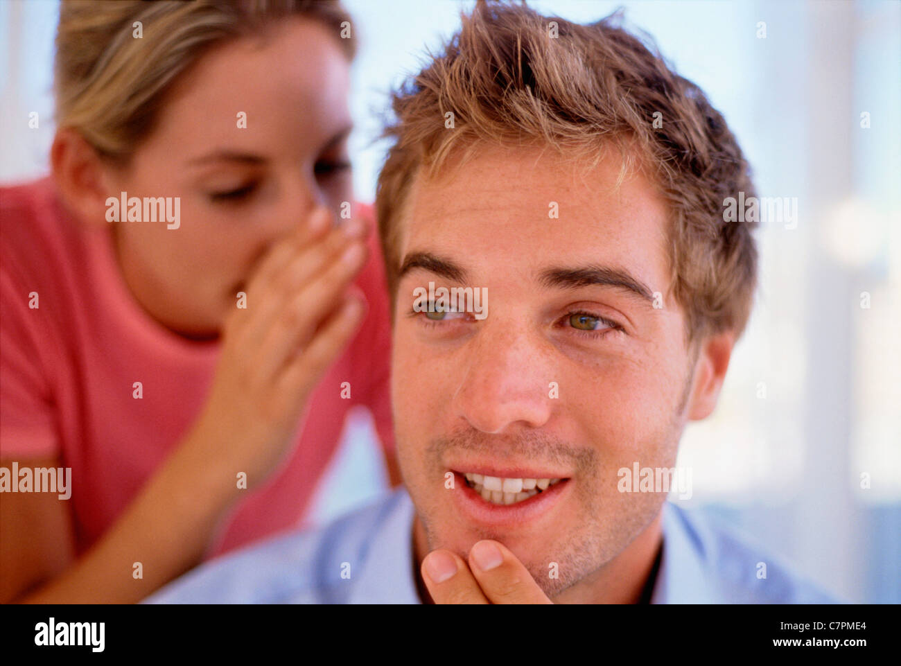 Woman whispering in man’s ear Stock Photo - Alamy