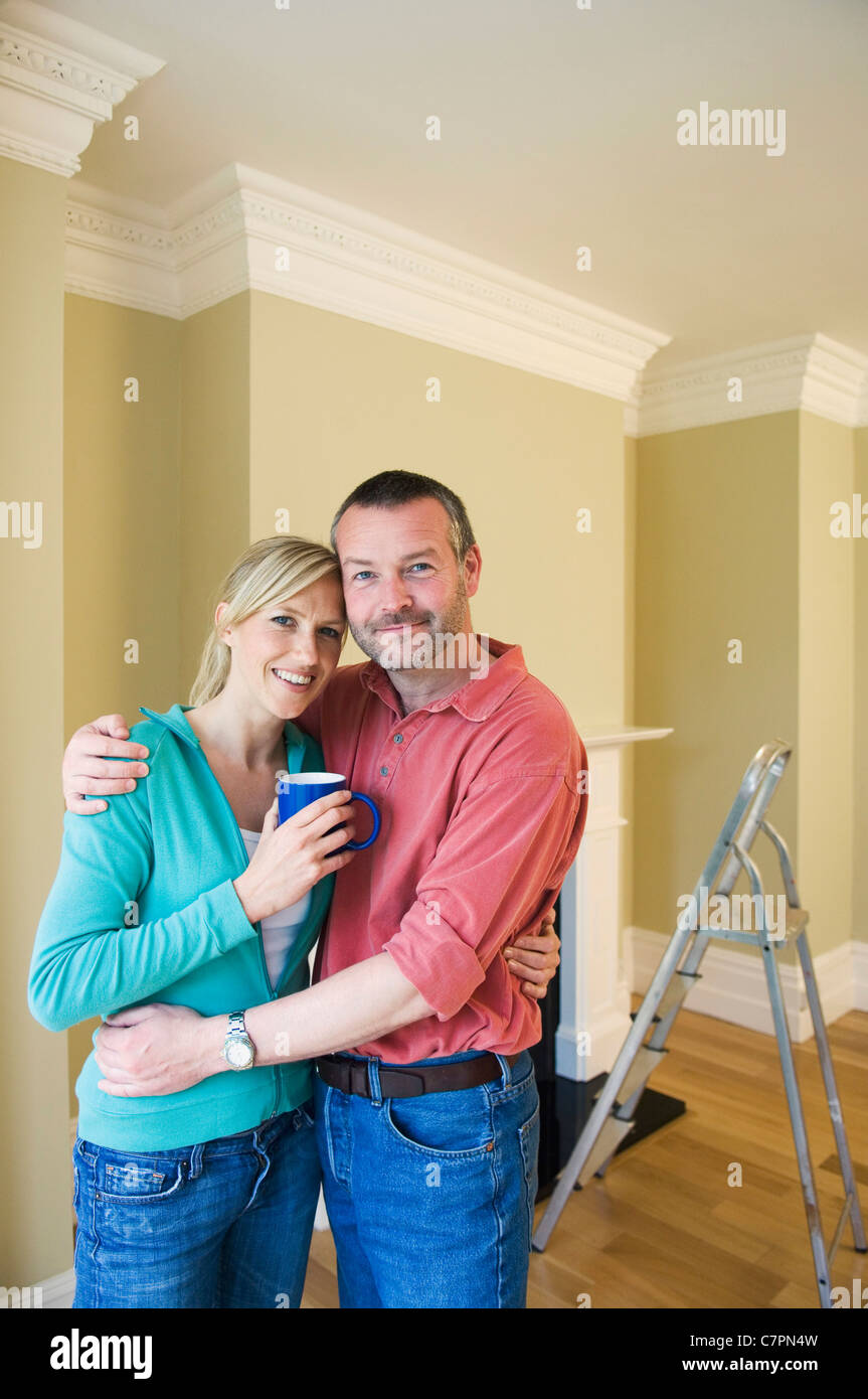 Smiling couple hugging in new home Stock Photo - Alamy