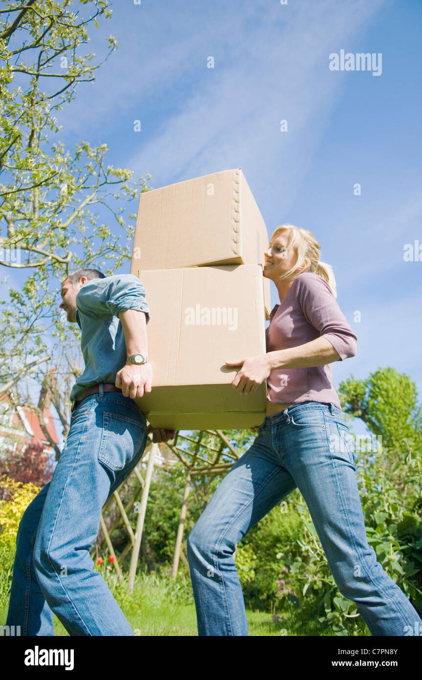 Couple carrying cardboard boxes Stock Photo - Alamy