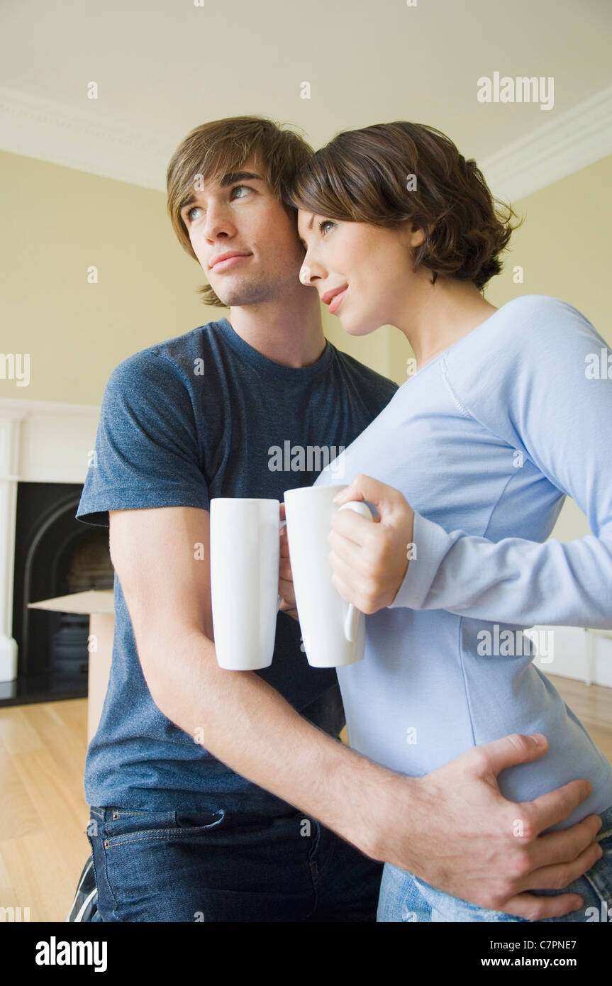 Couple hugging with coffee in new home Stock Photo - Alamy