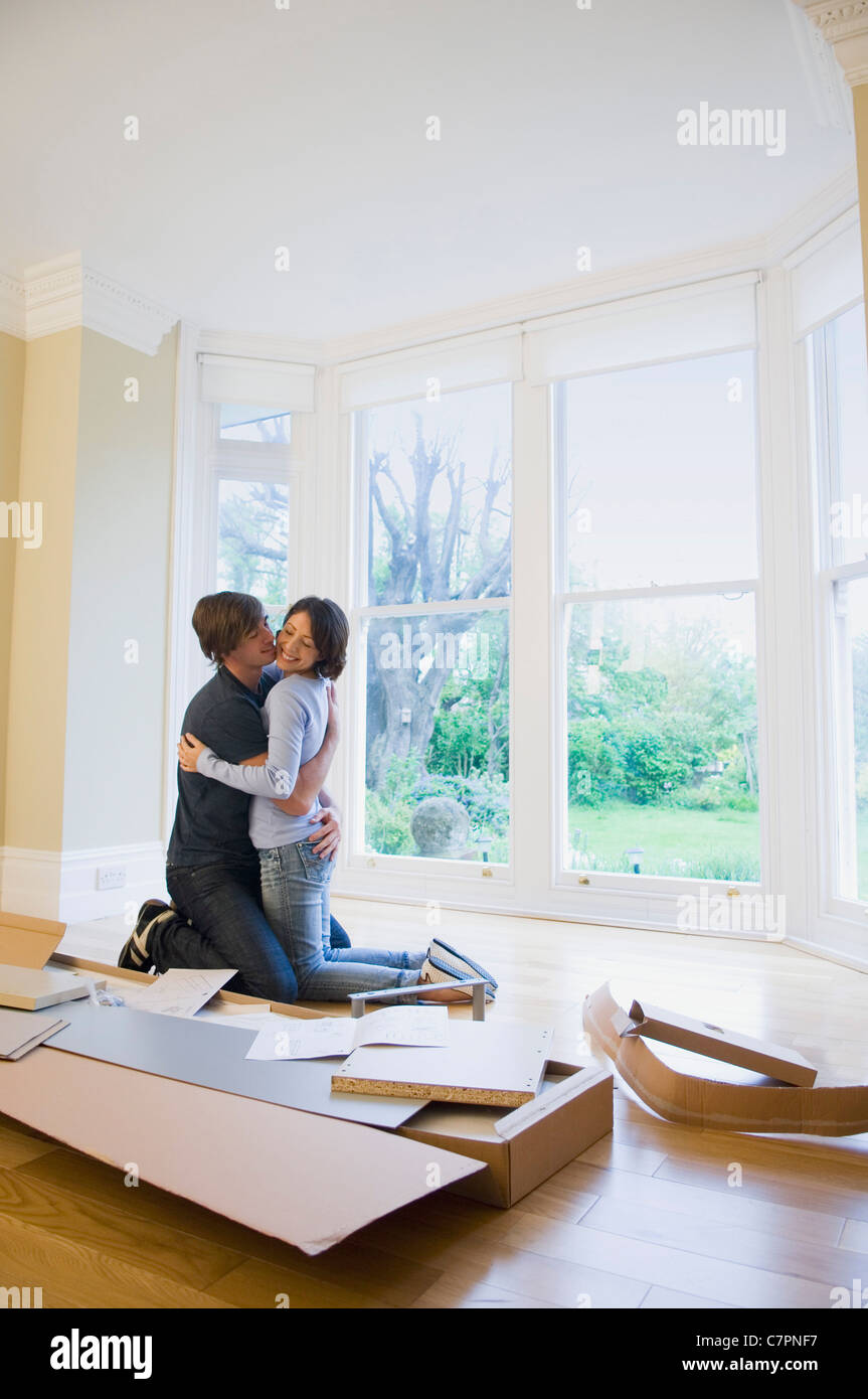 Couple hugging in new home Stock Photo - Alamy