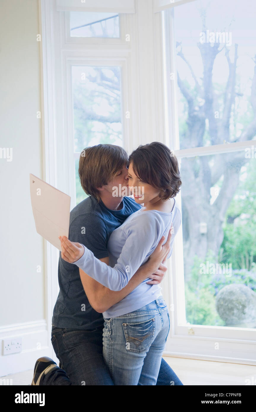 Couple hugging in front of window Stock Photo - Alamy