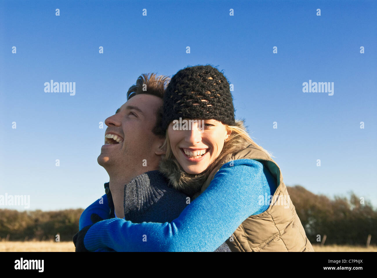 Smiling couple hugging in field Stock Photo - Alamy