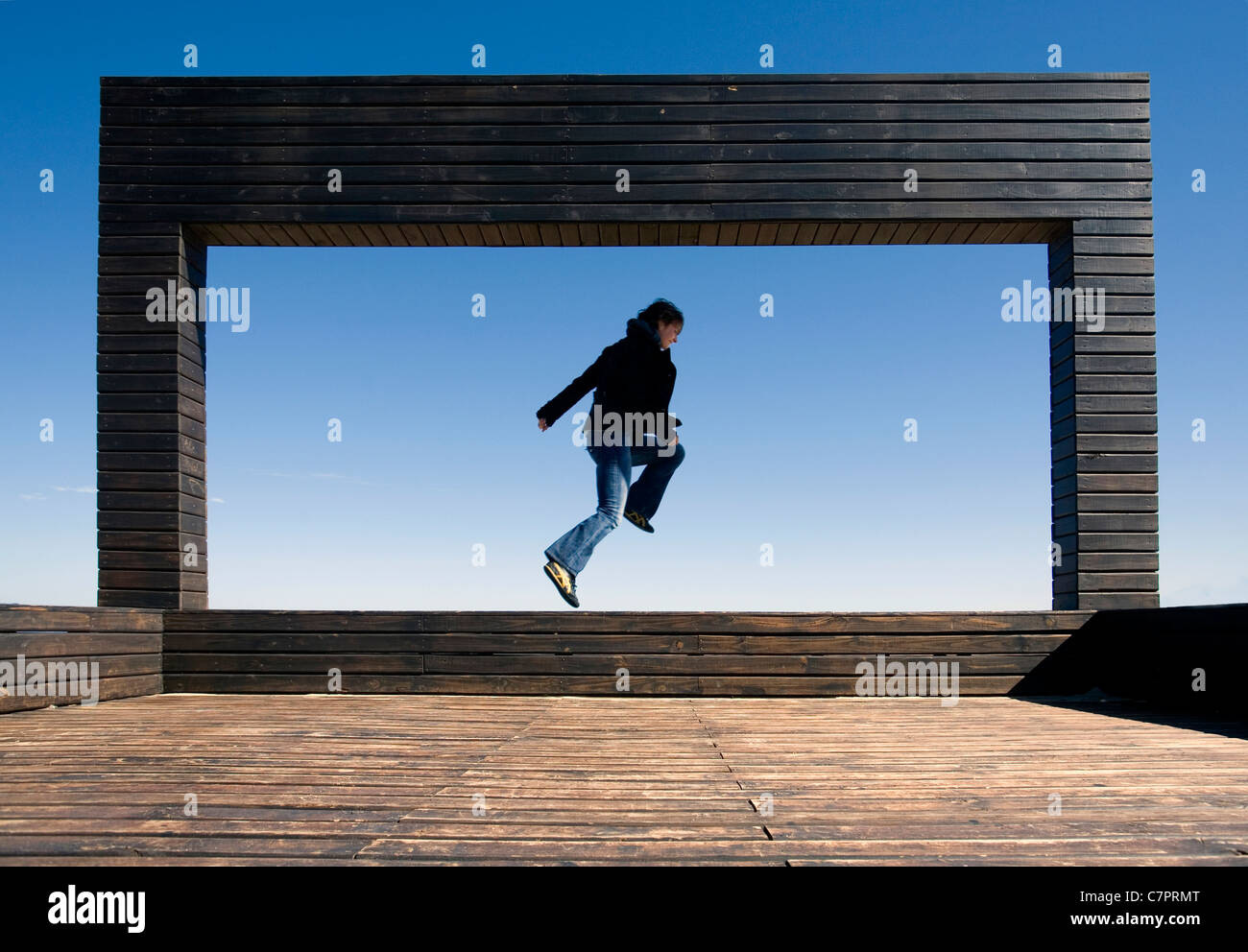 Young woman jumping from a window frame Stock Photo - Alamy