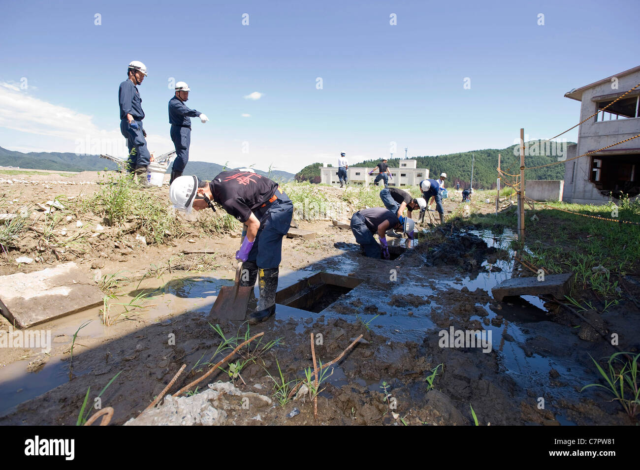 Police dig mud from the drains in search of human remains outside Okawa ...