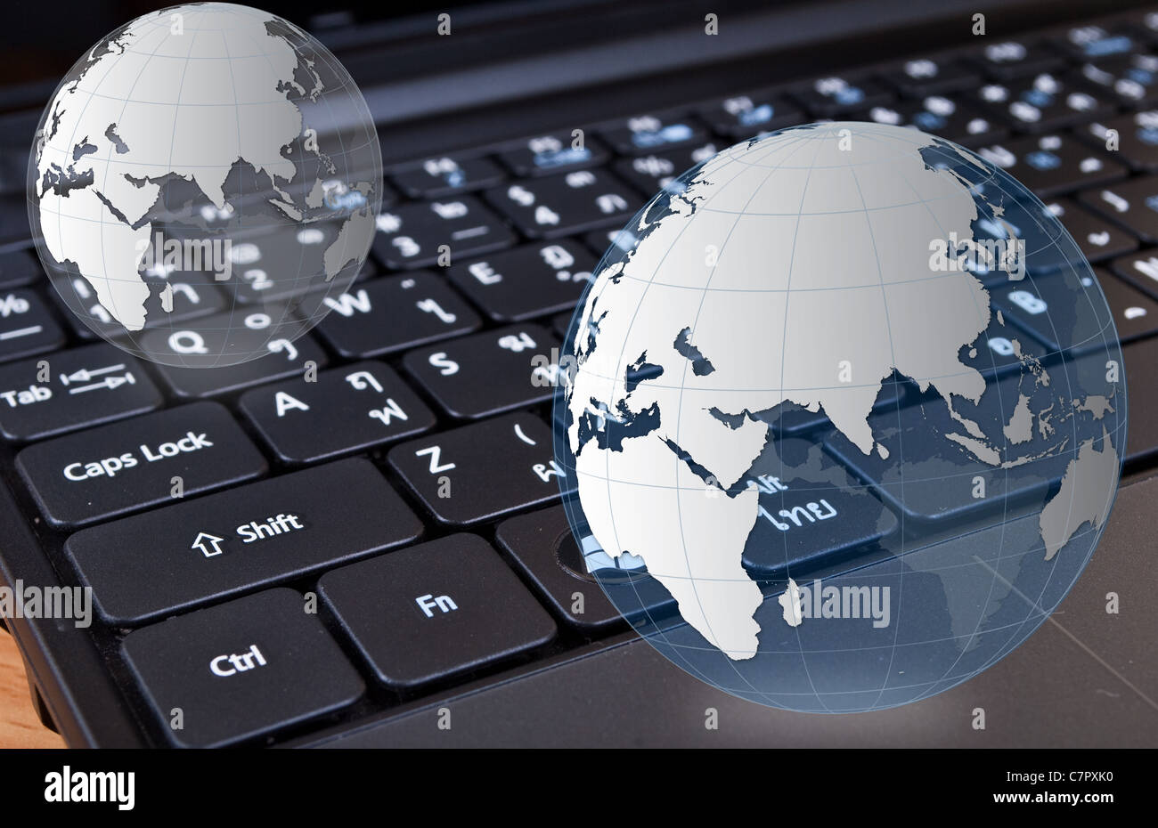 Globe on laptop keyboard Stock Photo - Alamy