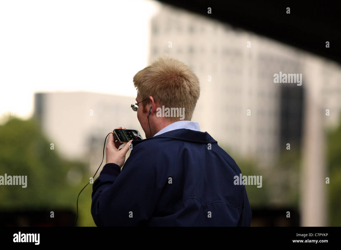 a man talking into his mobile phone and wearing earphones Stock Photo ...