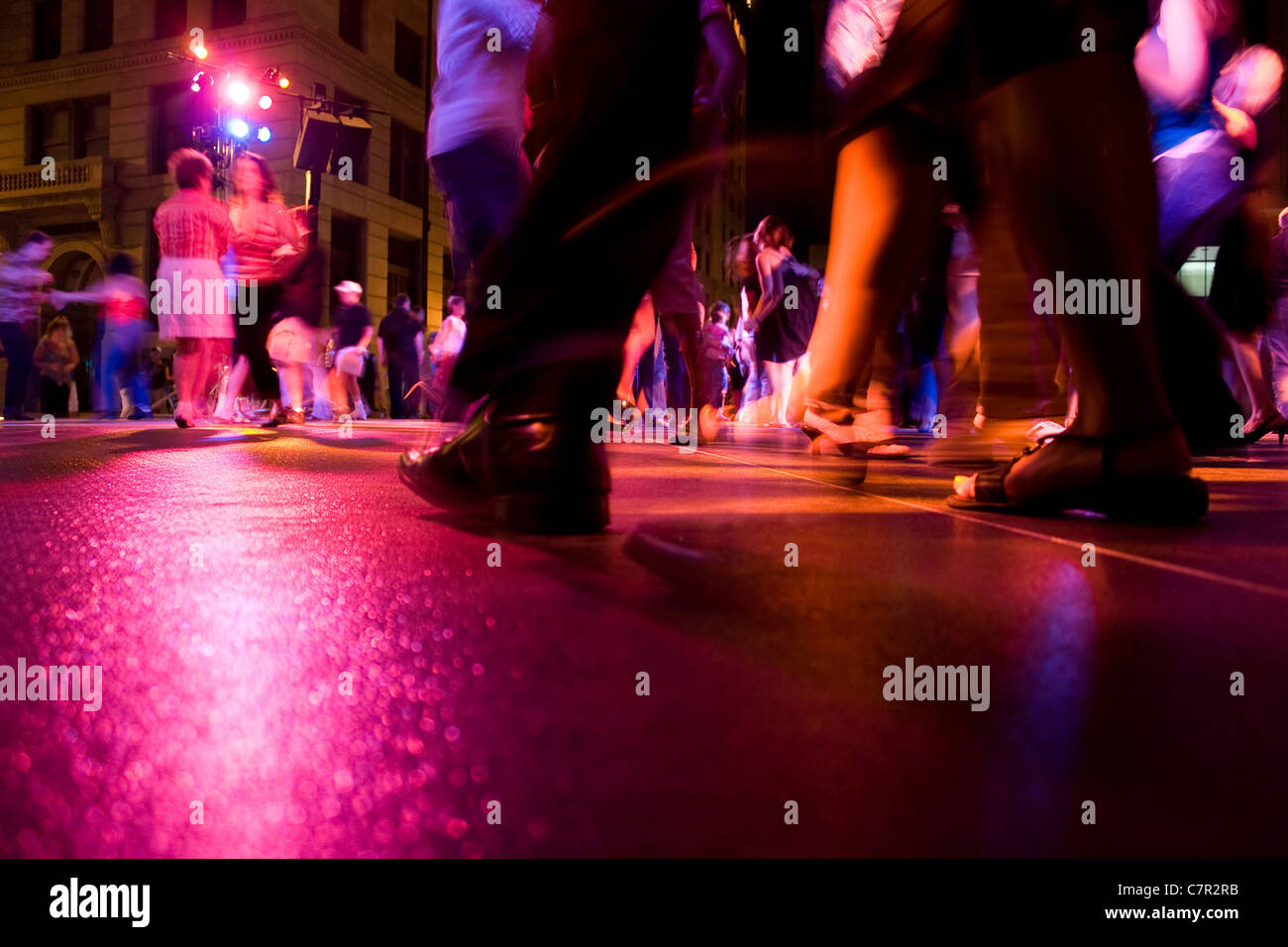 A low shot of the dance floor with people dancing under the colorful ...
