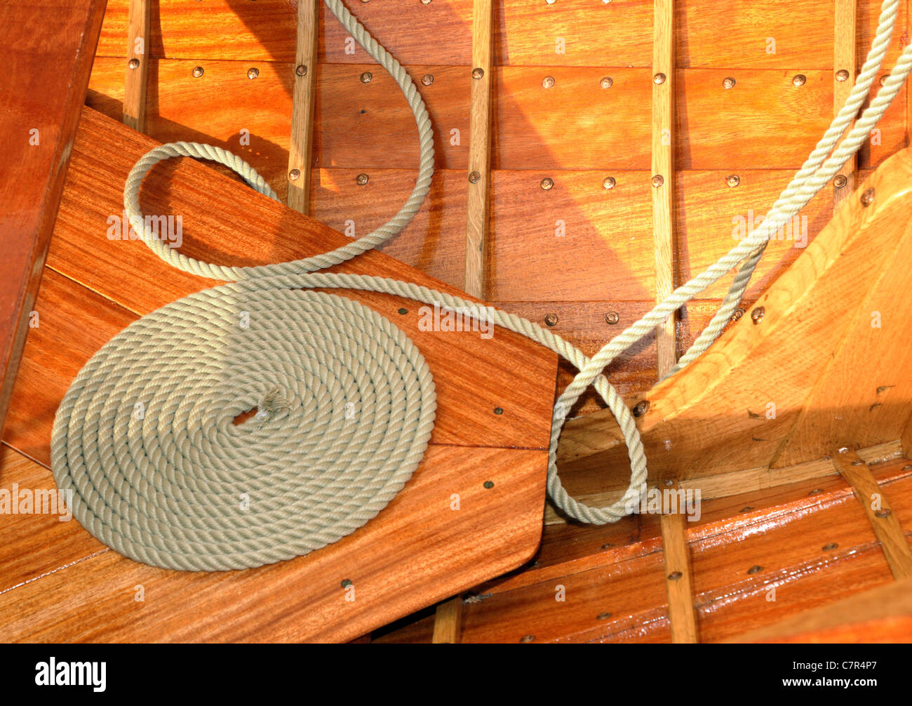 Coiled rope on teak deck. Decorative coiling is called 'cheesing' or ...