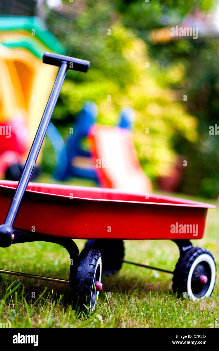 A childs red pull cart trolley for playing in the garden and collecting ...