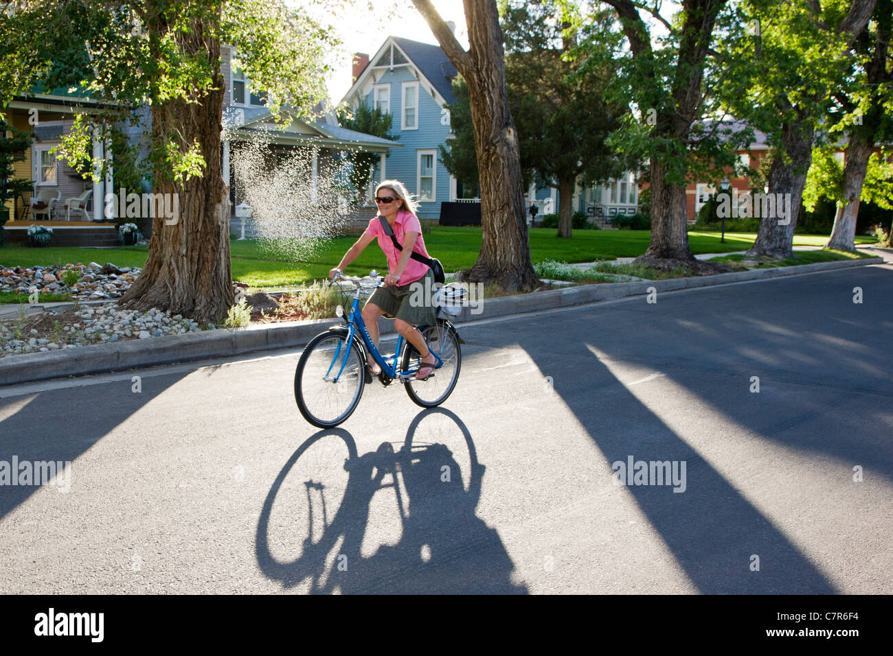 Woman riding her commuter bike in the small mountain town of Salida ...