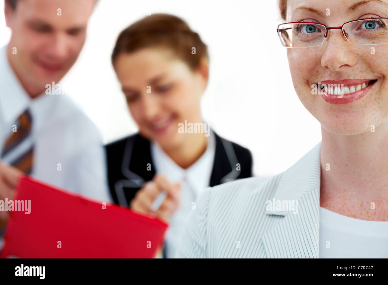 Female manager smiling against her two colleagues Stock Photo - Alamy