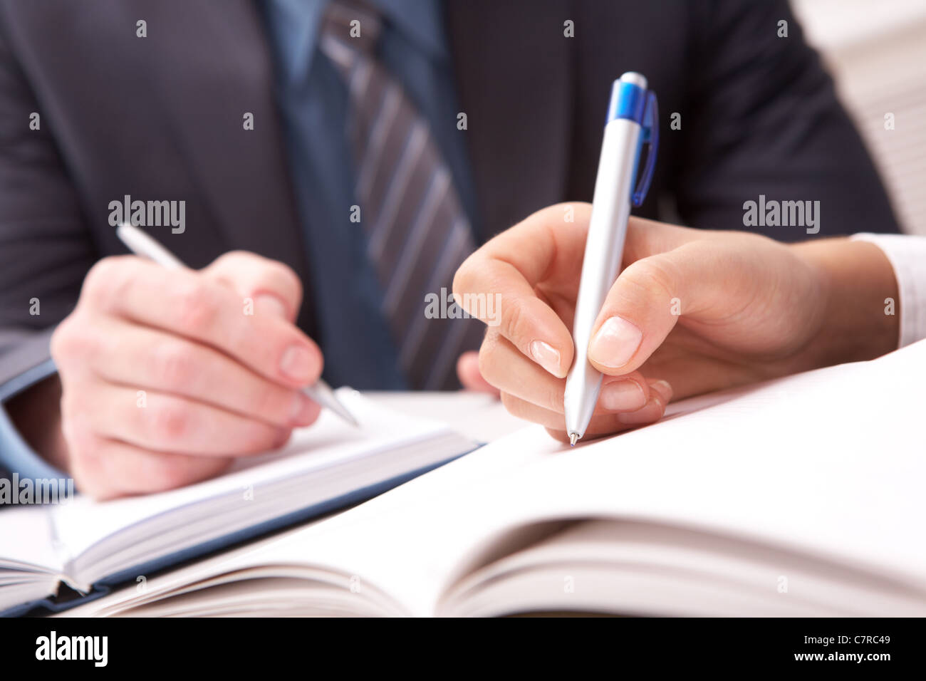 Male and female hands writing in notebooks Stock Photo - Alamy