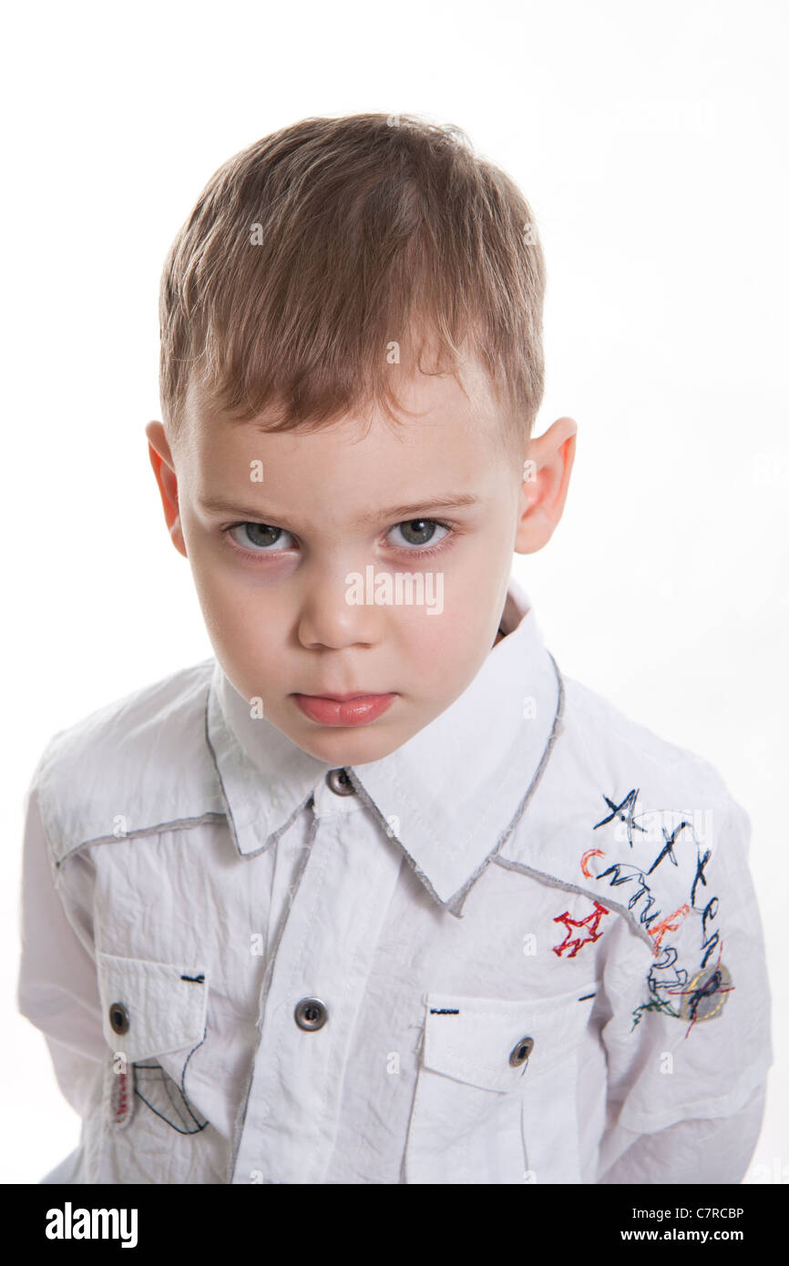 Serious boy standing on white background Stock Photo - Alamy