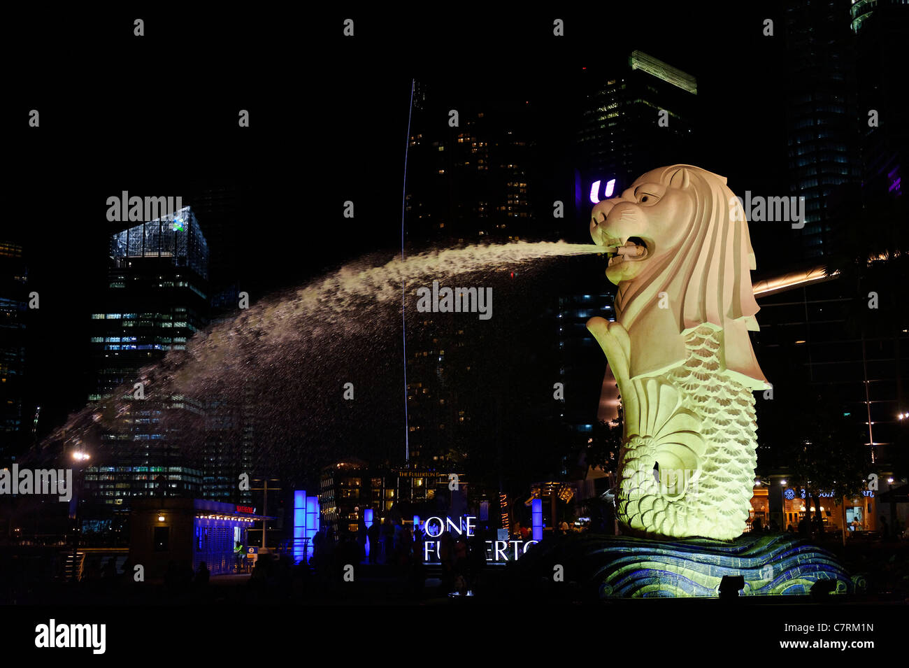 Floodlit Singapore Merlion fountaining spouting water at night with the ...
