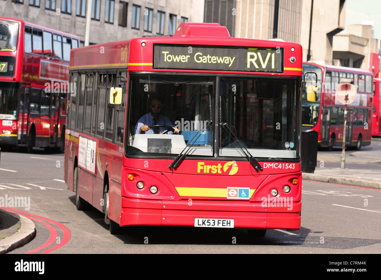 A single decker red London bus with other red London buses in the ...