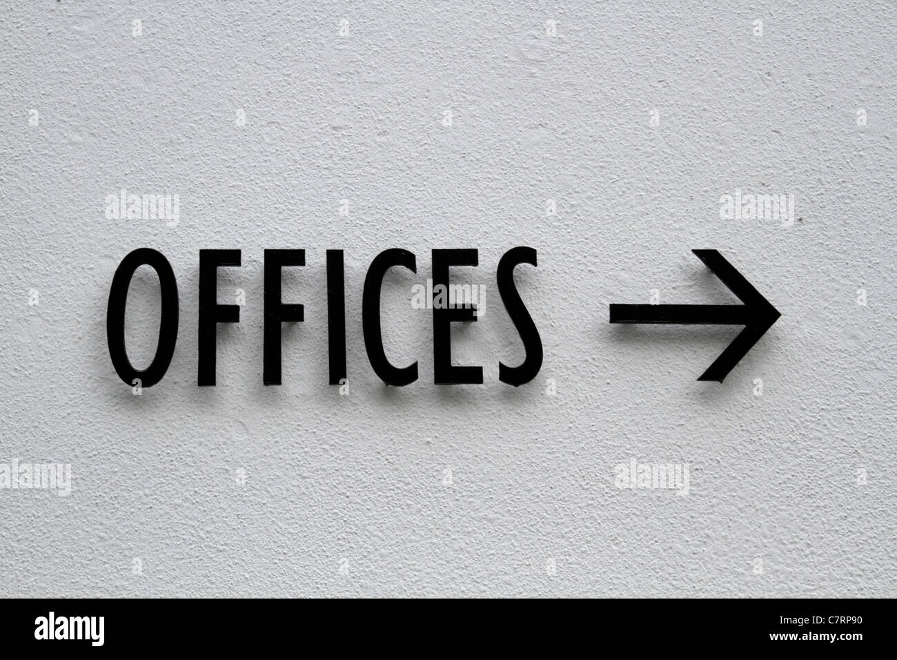 Office Sign black on white wall - Offices with arrow Stock Photo - Alamy