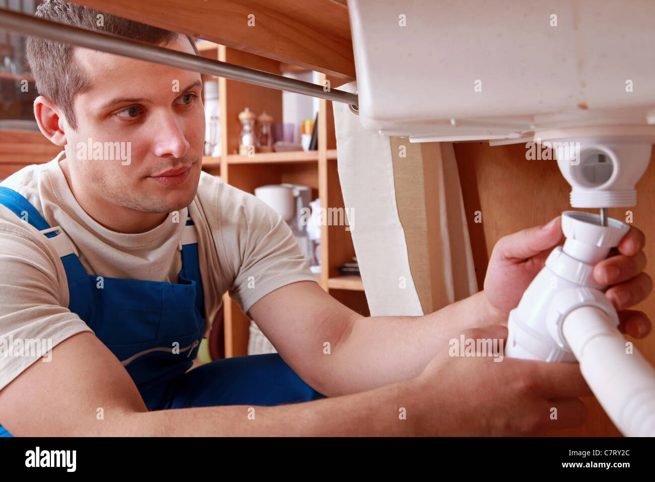 Plumber fixing sink Stock Photo - Alamy