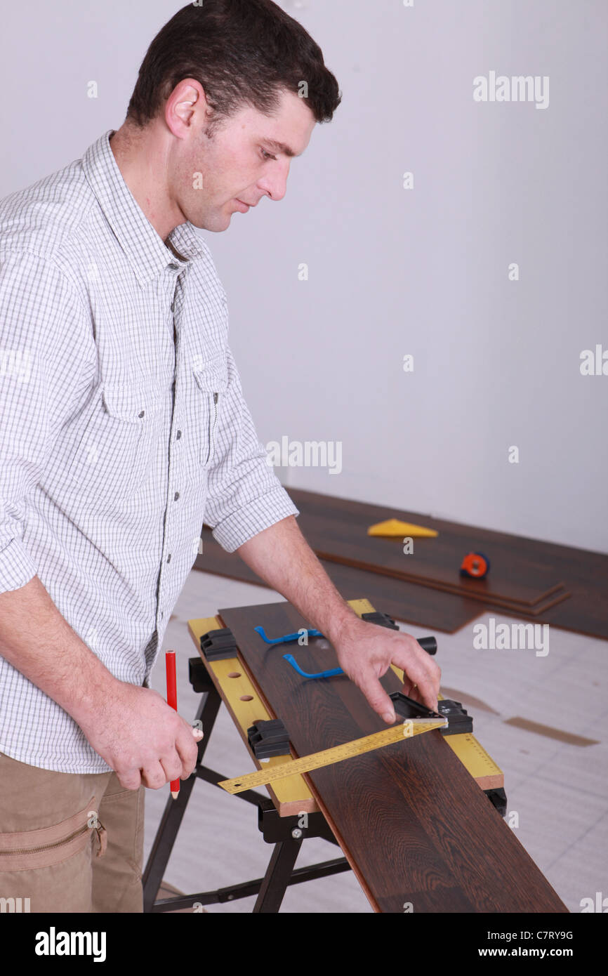 Man measuring plank of wood Stock Photo - Alamy