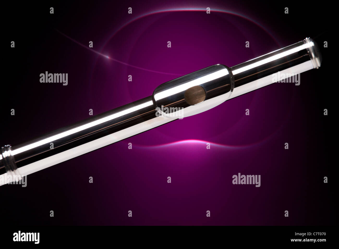 A silver flute isolated against a purple back ground in the horizontal ...