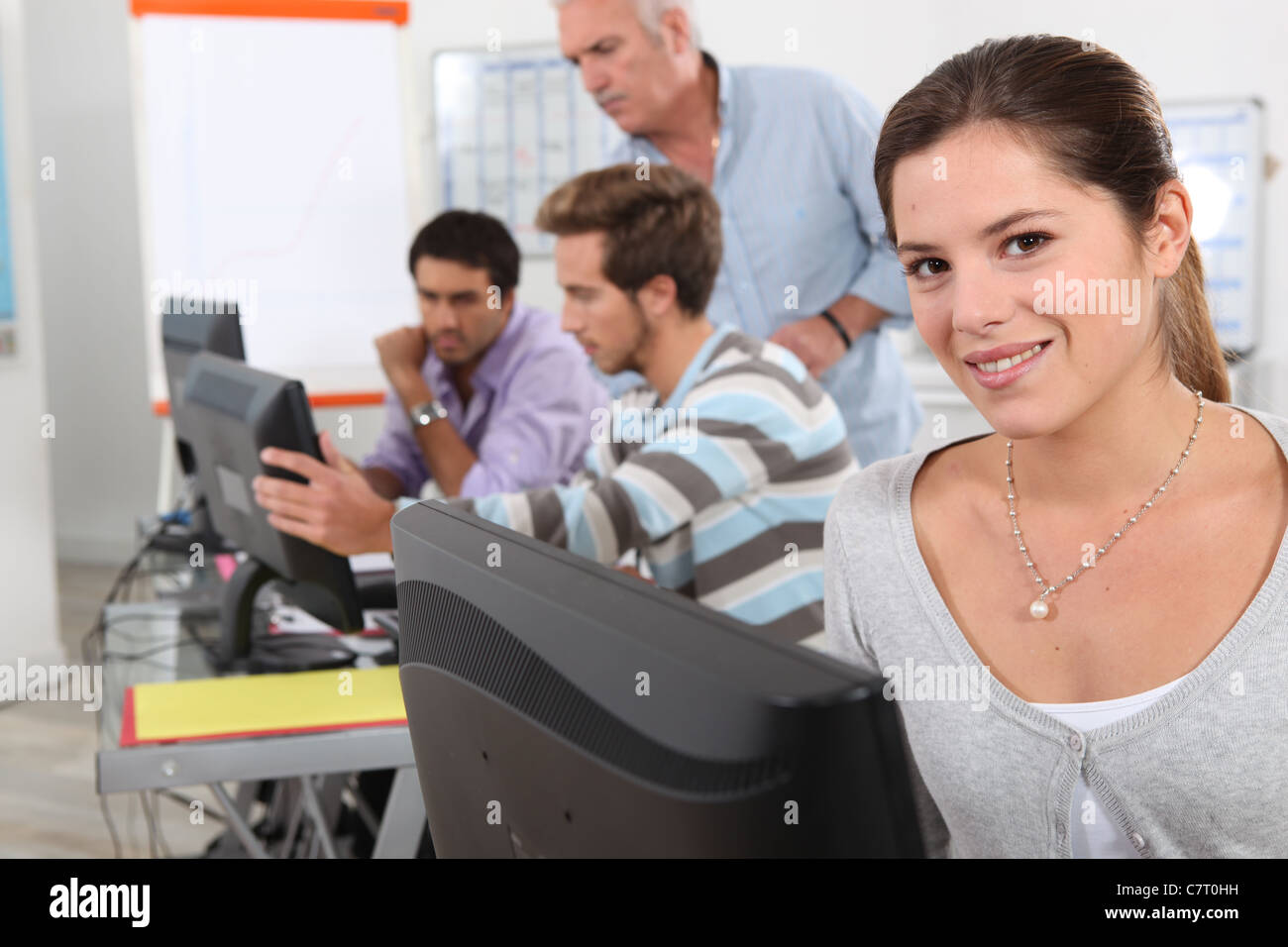 Teacher helping students use computers hi-res stock photography and ...