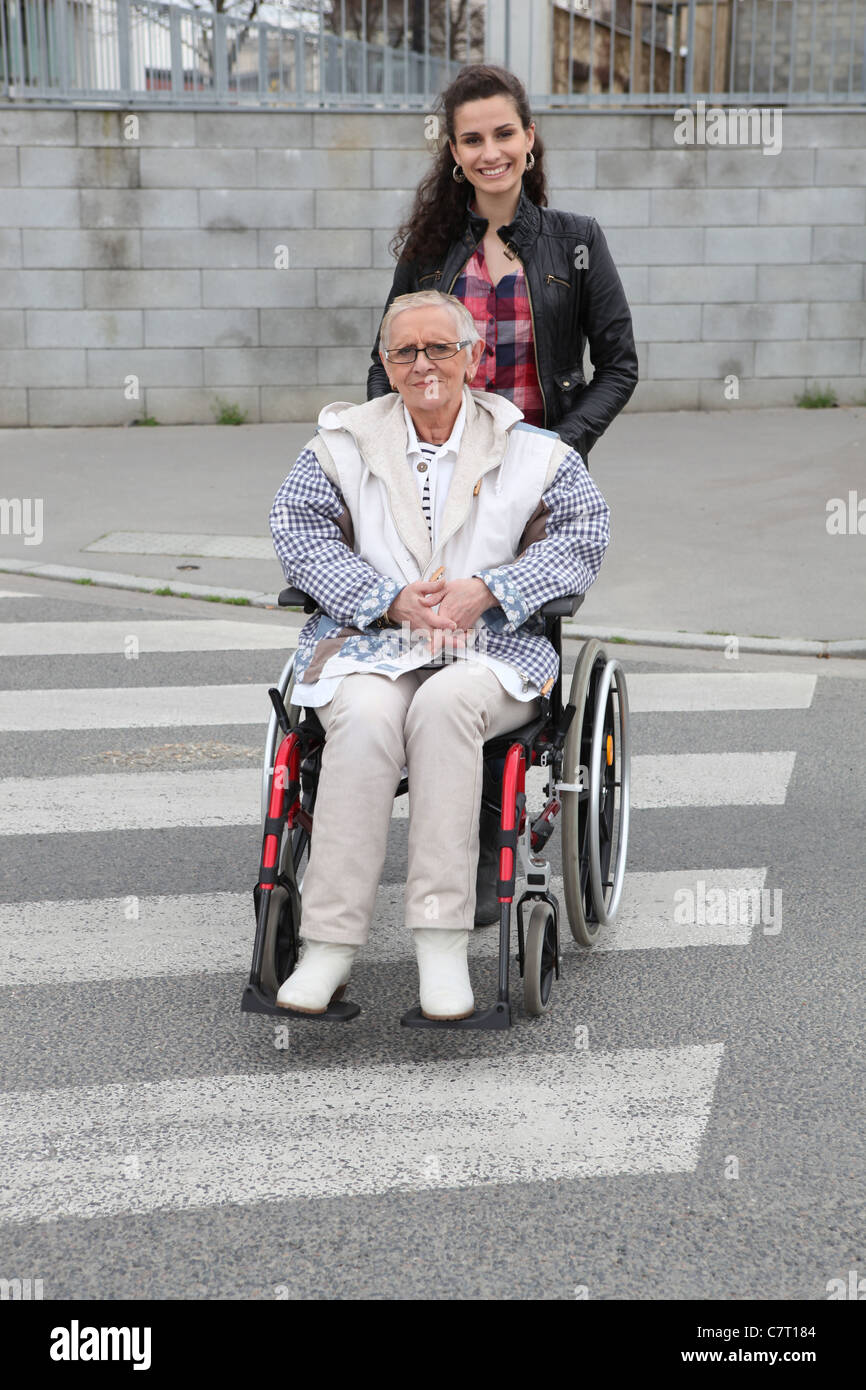 Girl pushing senior woman in wheelchair Stock Photo - Alamy