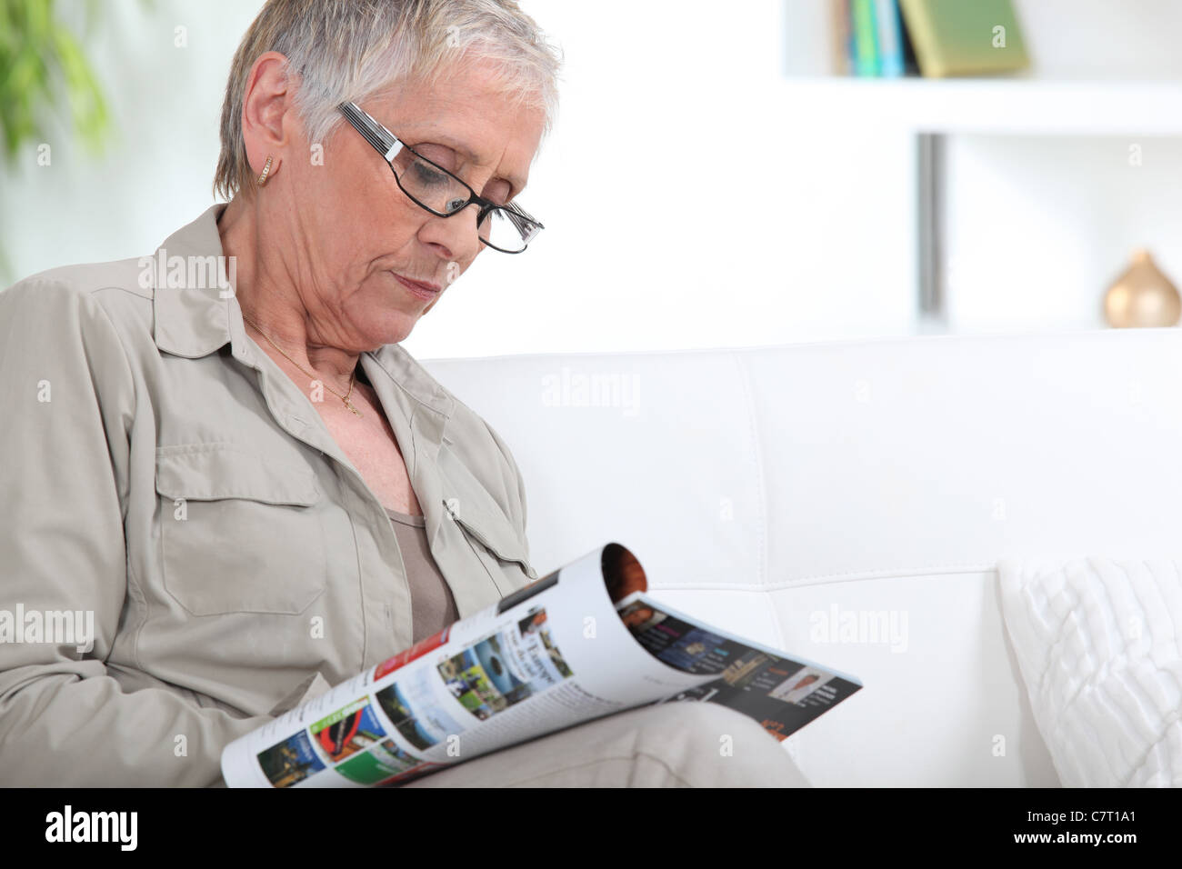 Elderly woman reading magazine Stock Photo - Alamy