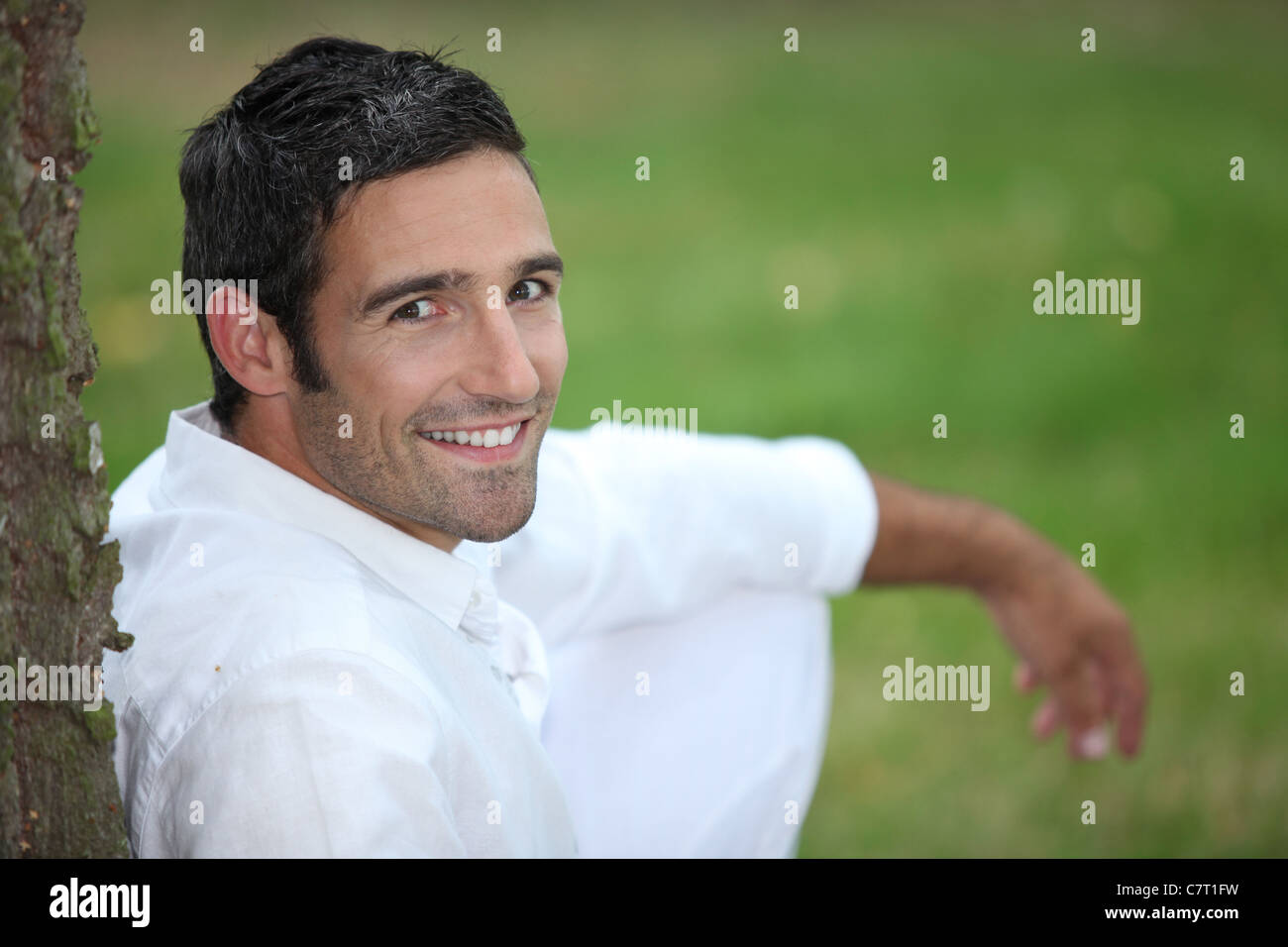 Man leaning against a tree Stock Photo - Alamy