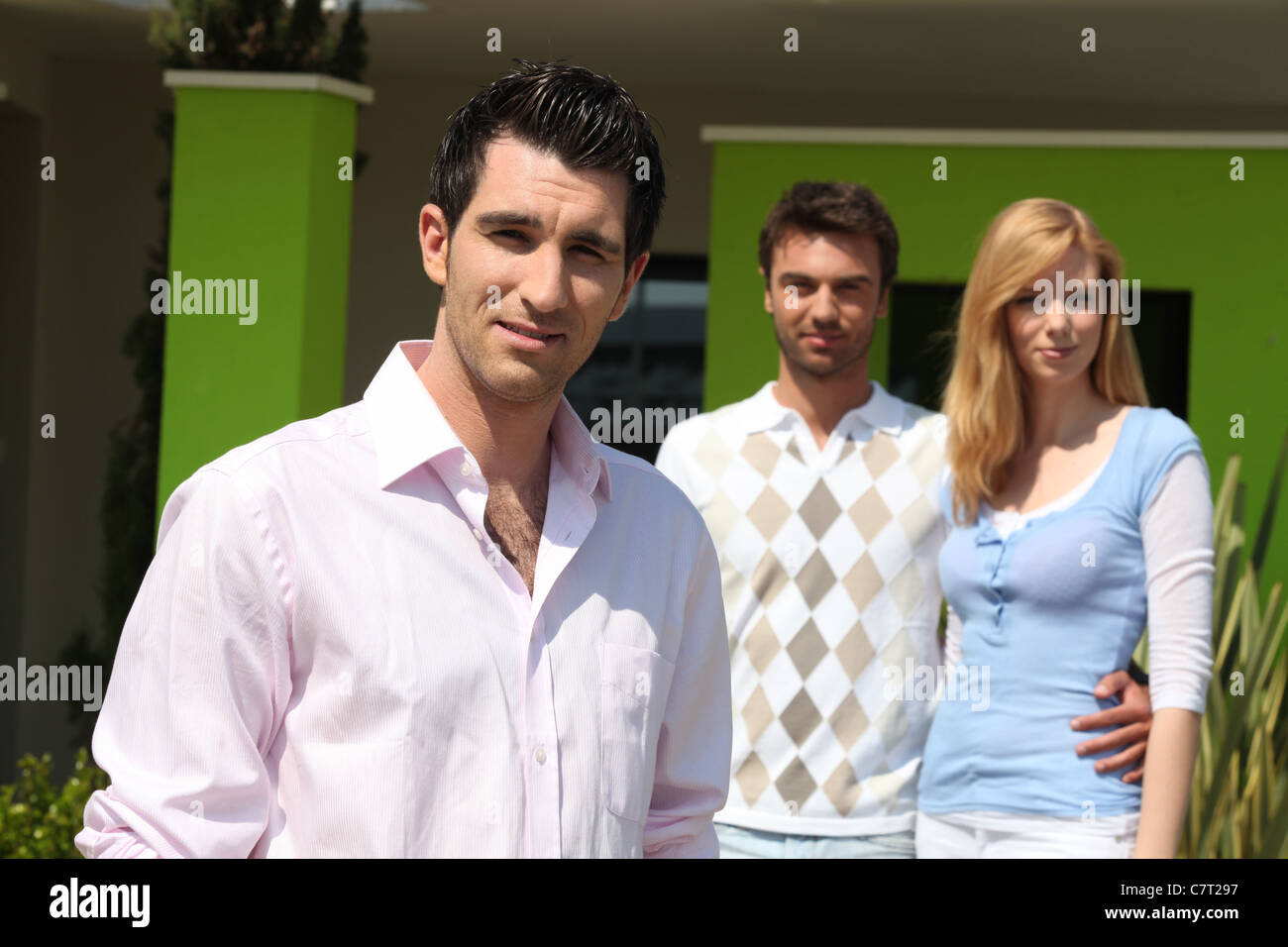 Man and couple in front of house Stock Photo - Alamy
