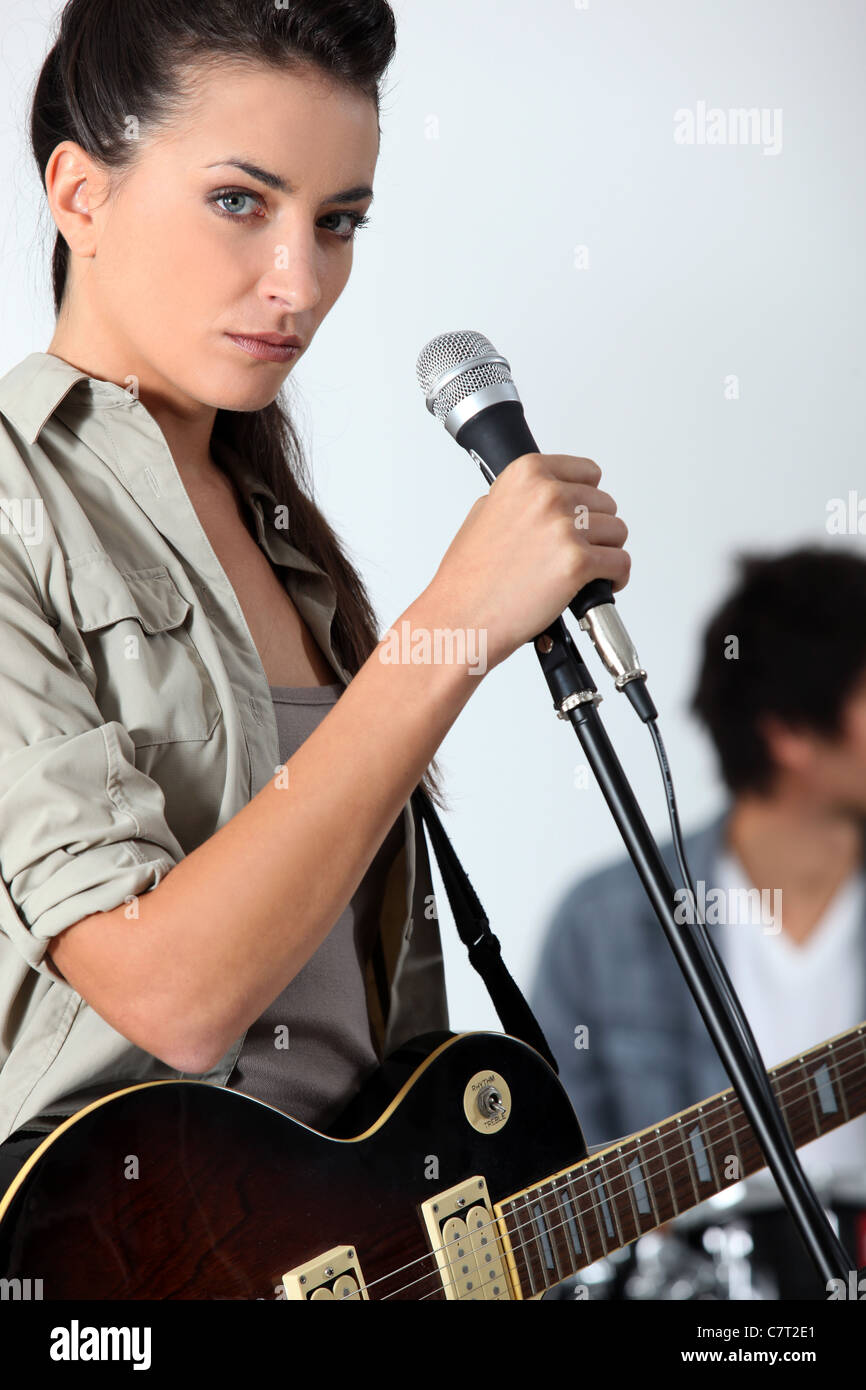 Young woman singer holding microphone Stock Photo - Alamy