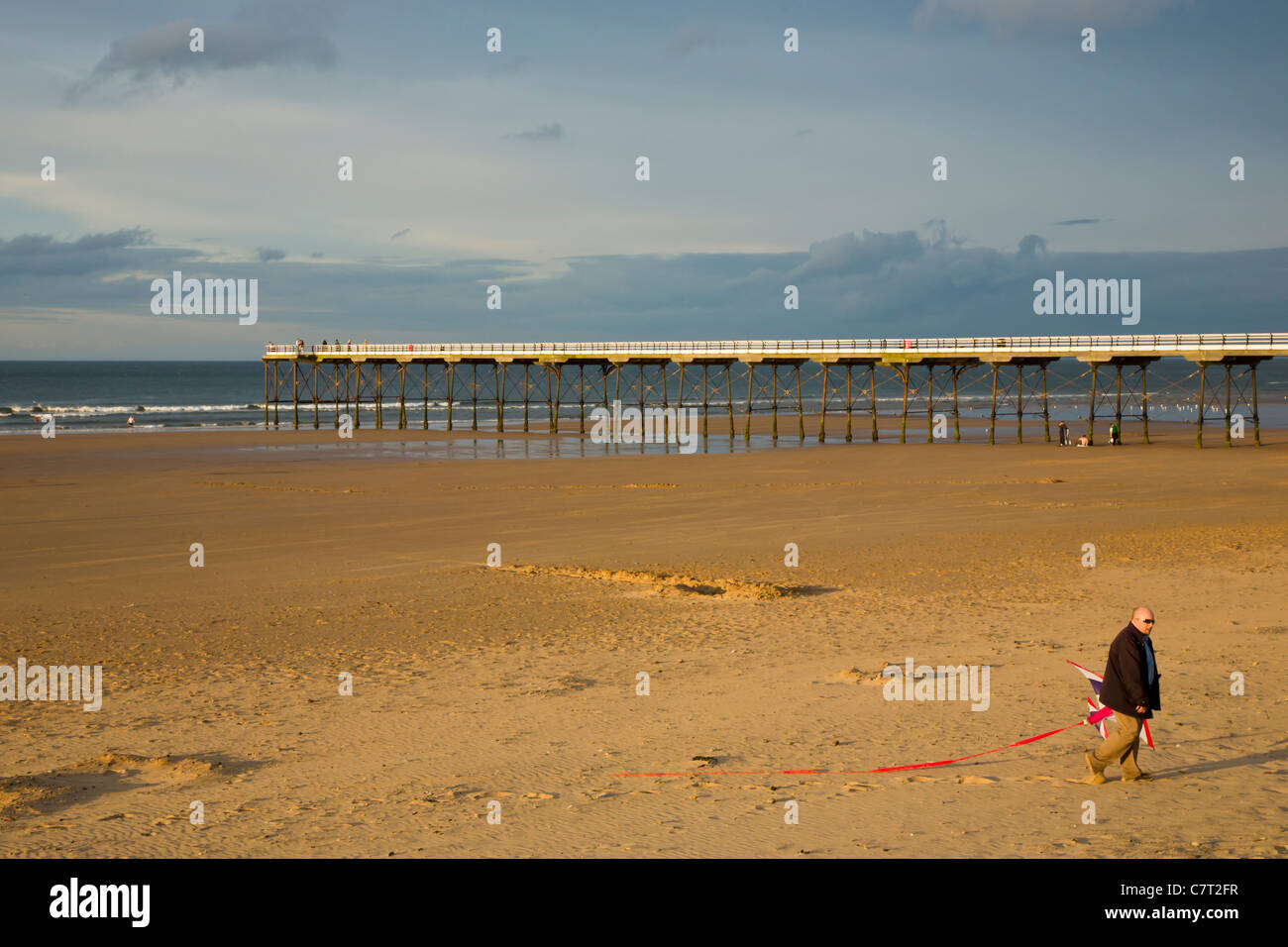Man on beach with Union Jack kite. Saltburn pier, evening, North ...