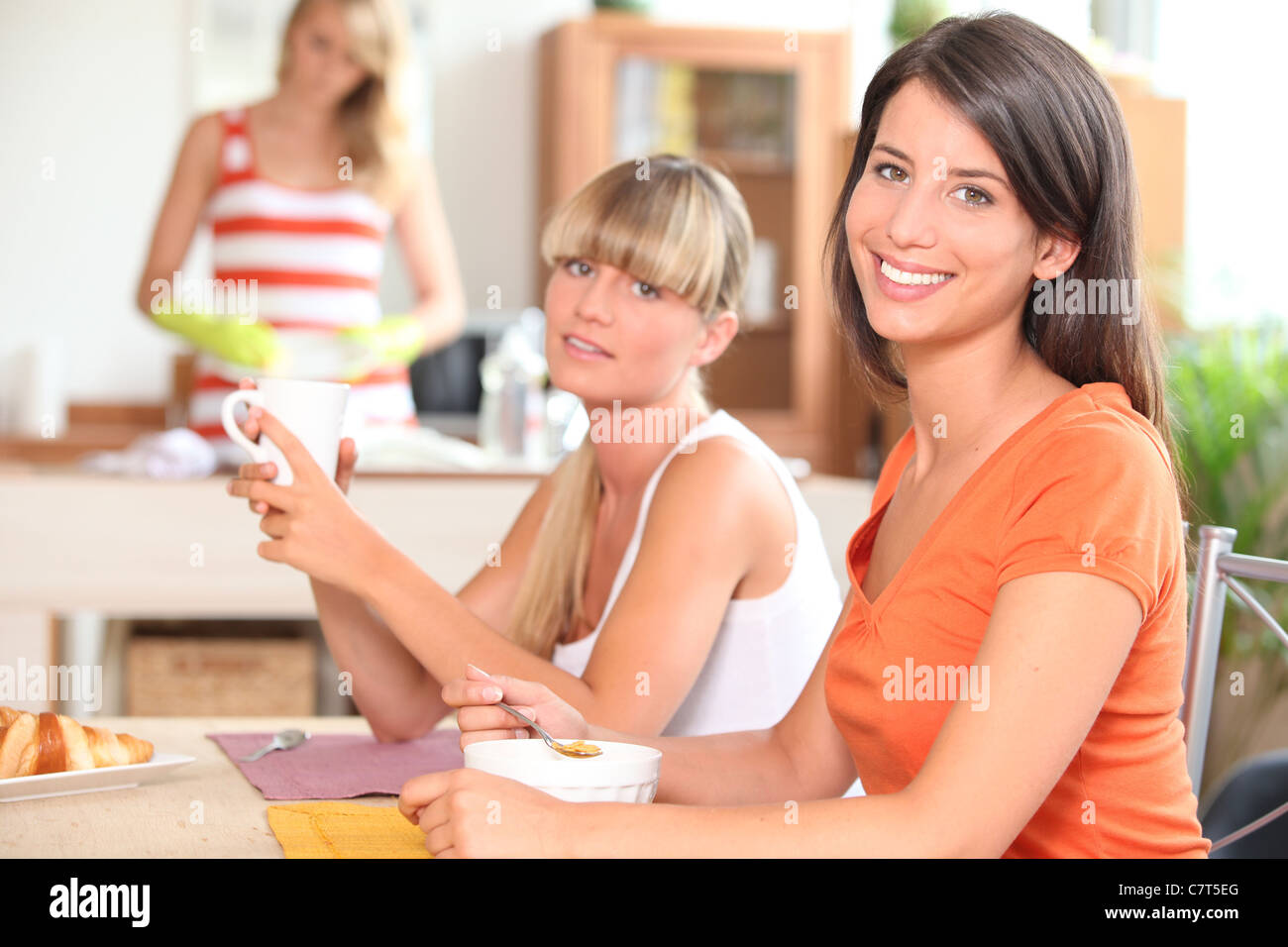 Three young women having breakfast at home Stock Photo - Alamy