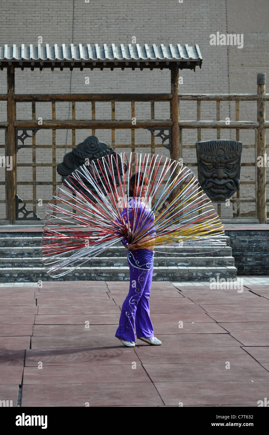 A female performer impresses the crowds by spinning multiple hula-hoops ...