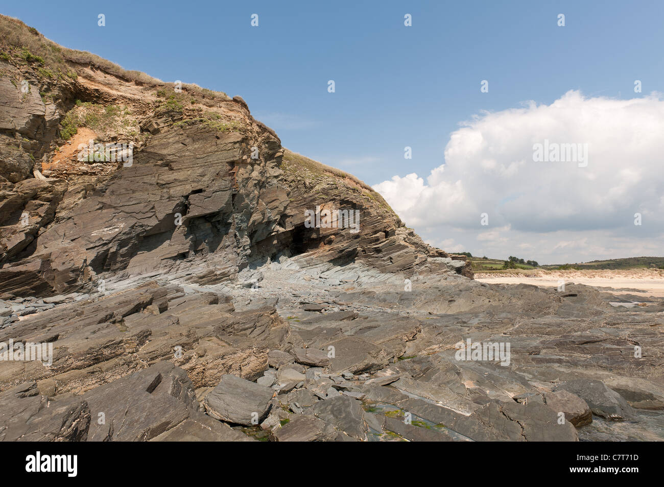 On dried exposed shale rocks at low tide looking back to land mass with ...