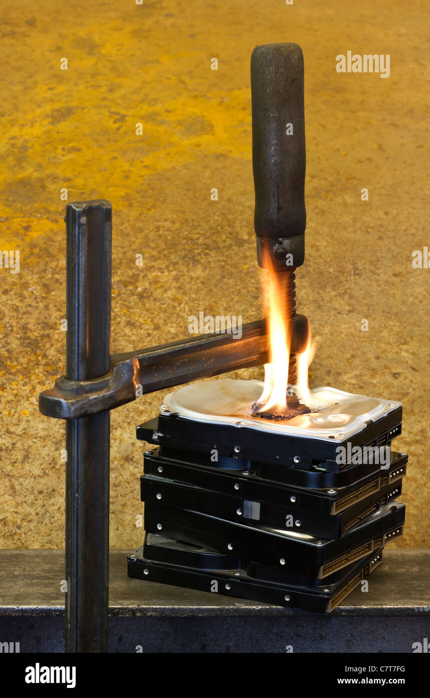 clamp pressing on burning stack of hard drives in rusty background ...
