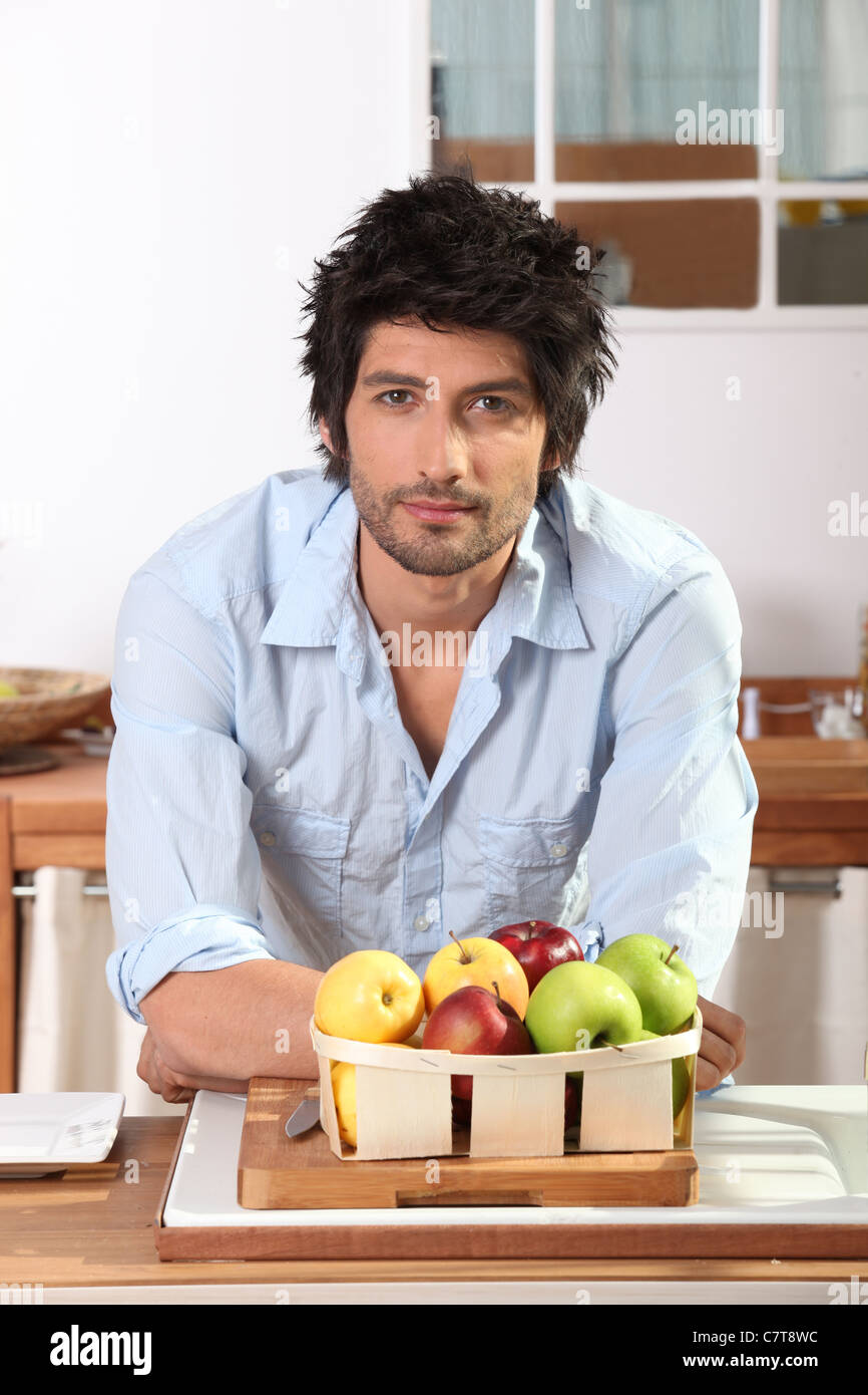 Man in kitchen leaning on countertop Stock Photo - Alamy