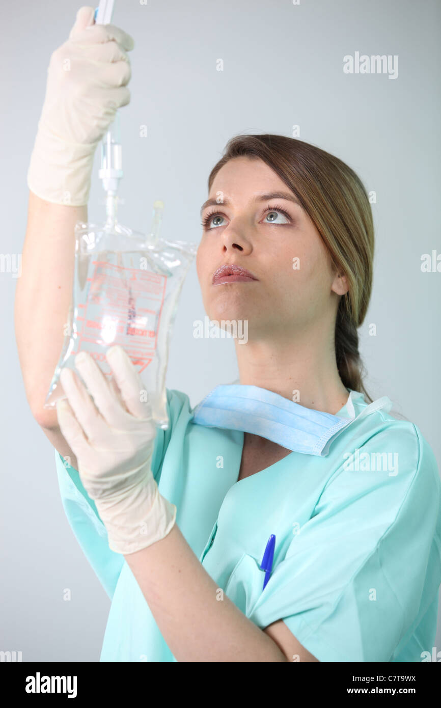 Female nurse administering a drip Stock Photo - Alamy