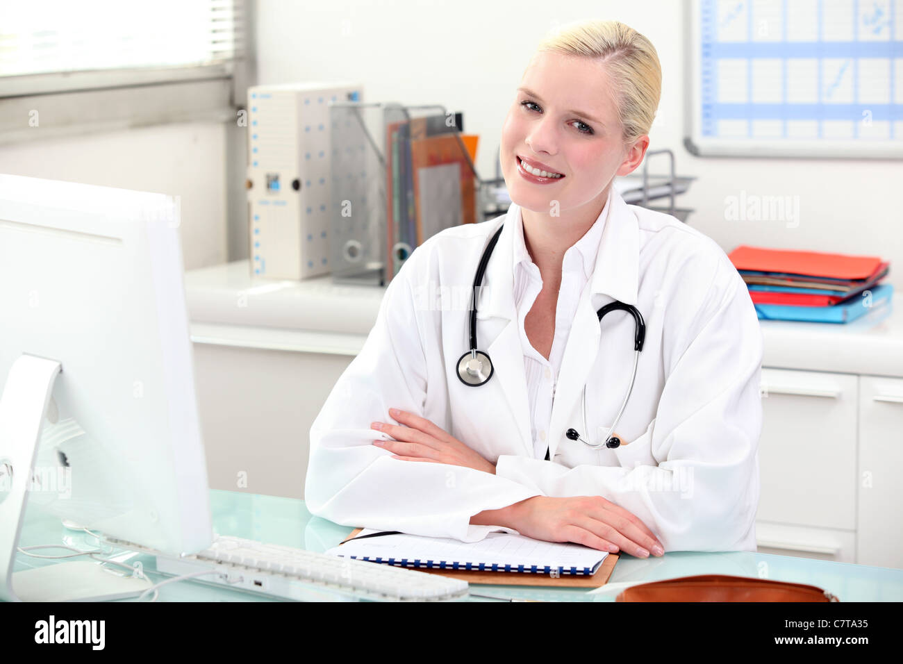 Doctor sitting behind her desk Stock Photo - Alamy