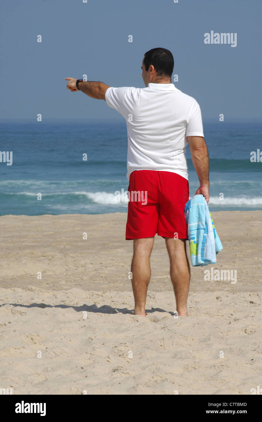 Men pointing the sea on the beach Stock Photo - Alamy