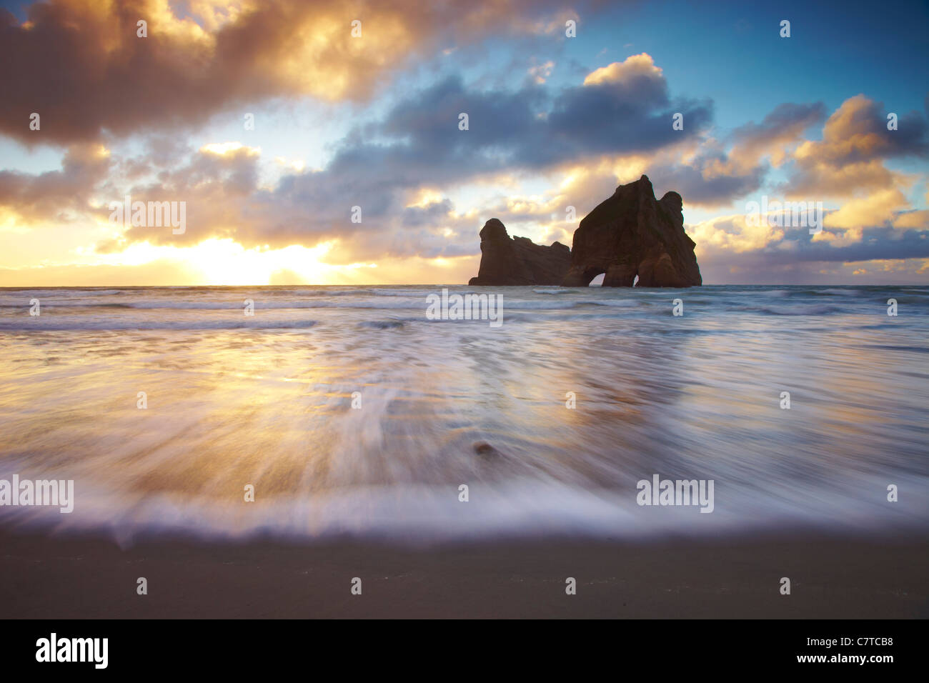 Wharariki Beach. The incoming tides rushes in on Wharariki beach as the ...