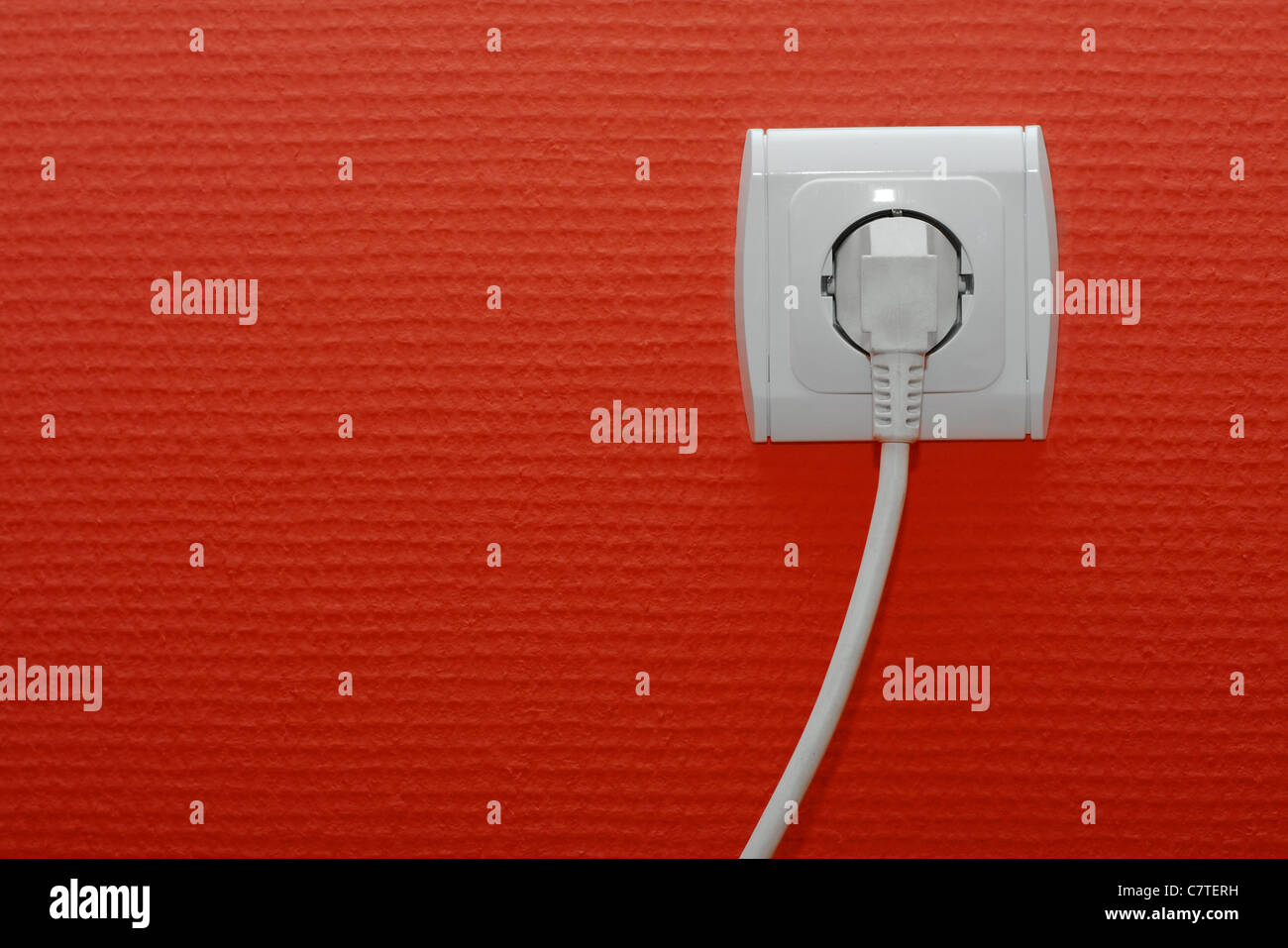 Electric outlet on red wall with cable connected Stock Photo - Alamy
