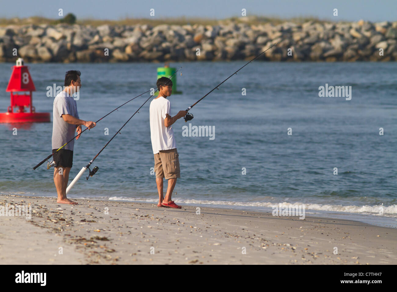 Two fishermen fishing in an inlet Stock Photo - Alamy