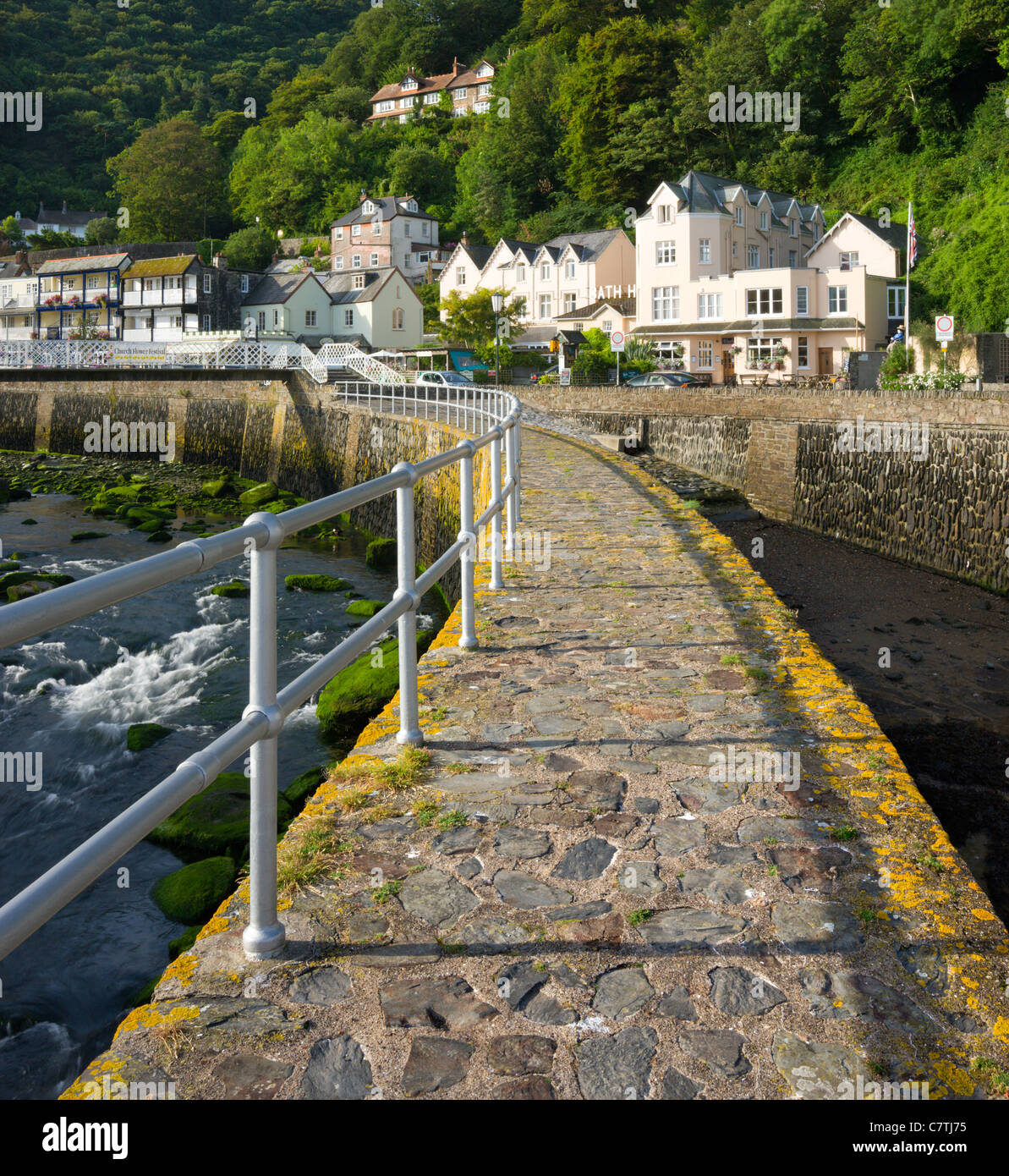 Stone harbour wall and village of Lynmouth on a summer morning, Exmoor ...