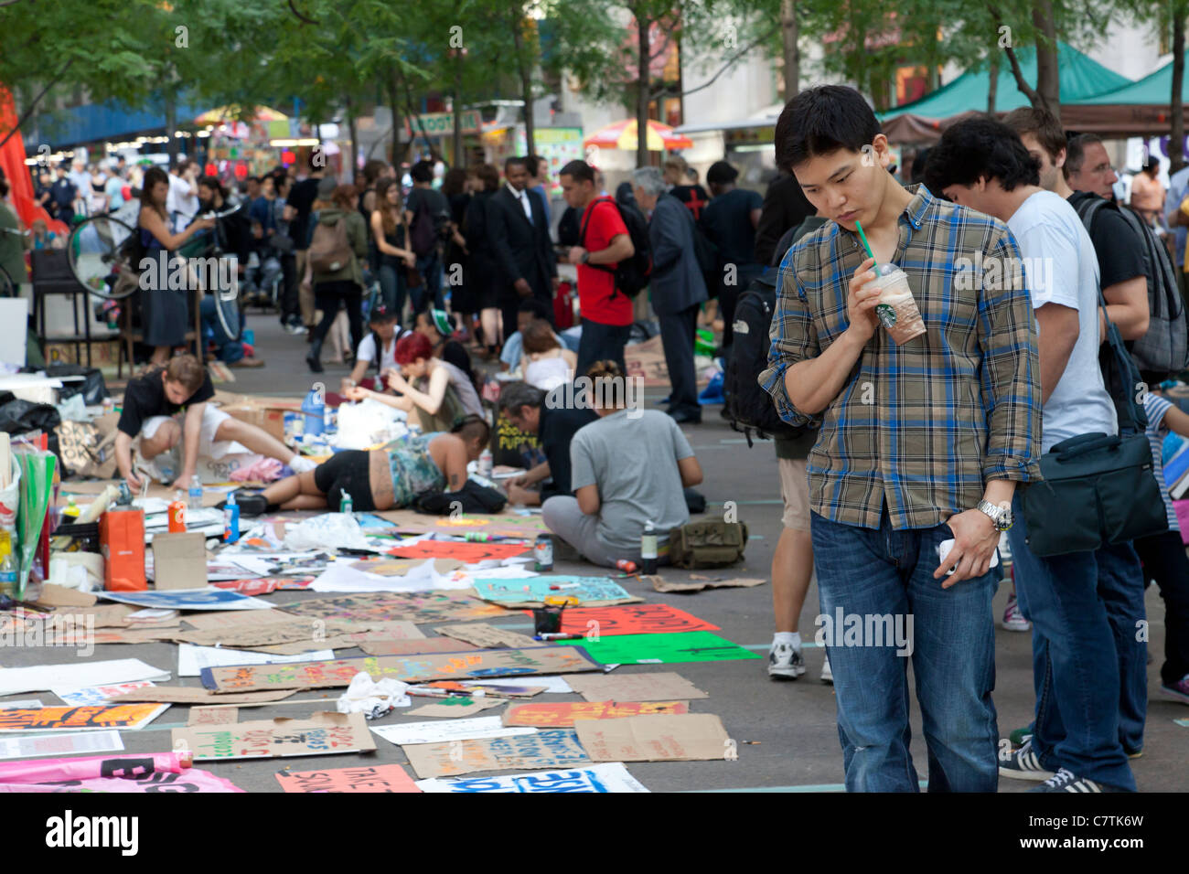 A passerby views protest signs displayed at Zucotti Park as part of the ...